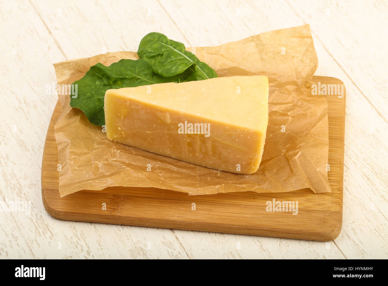 Parmesan cheese slice with salad leaves over the wooden background ...