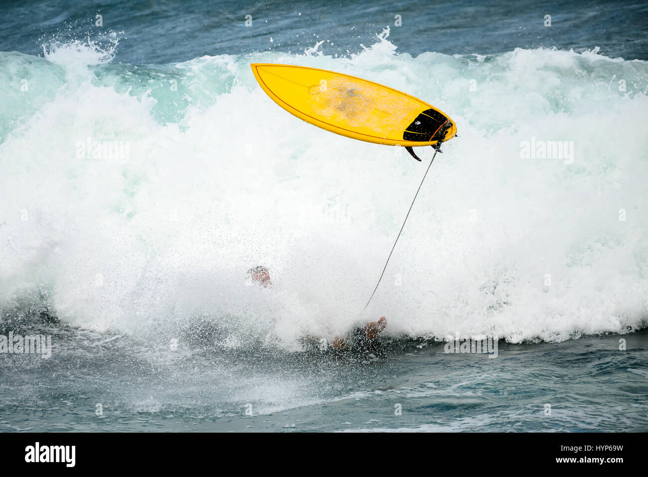 Surfer falls off his yellow board which is airborne Stock Photo - Alamy