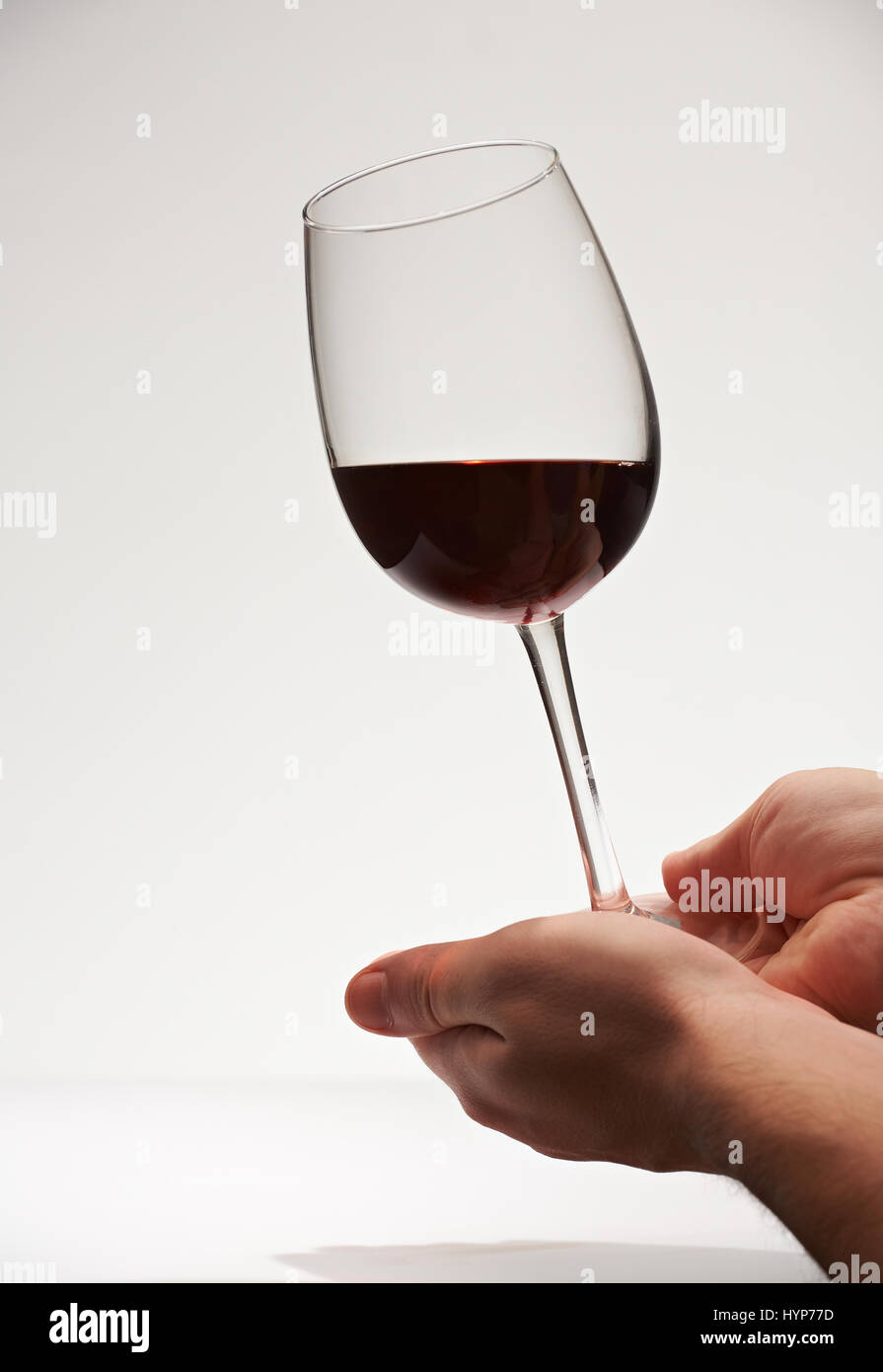 Hands holding red wine isolated on white background. One glass with red ...