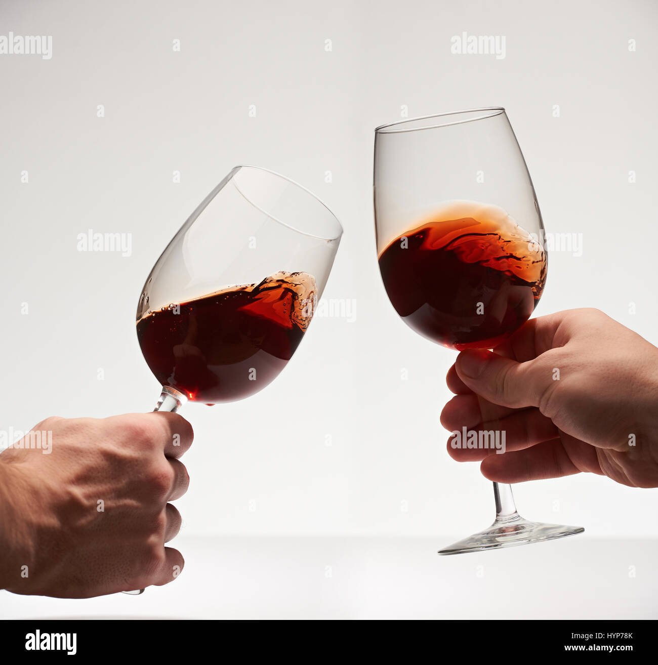 Happy cheers with two red wine glasses isolated on white background ...