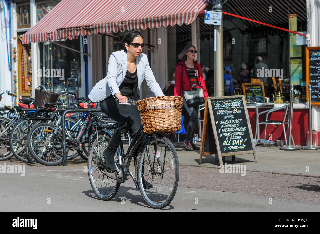 Woman lady cyclist riding a bike cycle bicycle in Cambridge ...