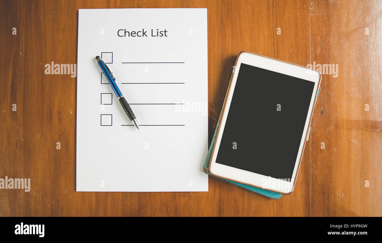 Top view of hand holding pen on check list paper with tablet Stock ...