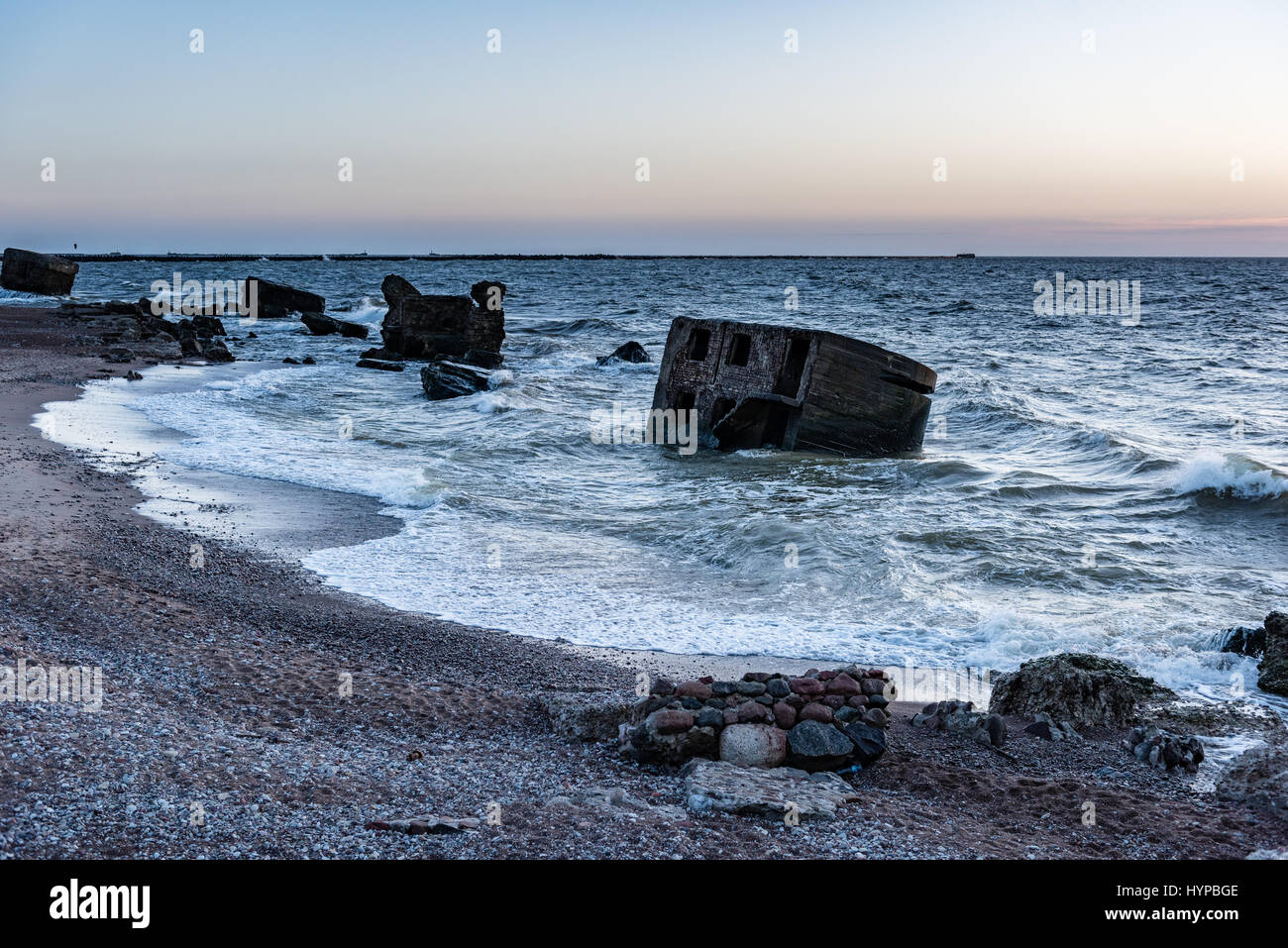 old war fort ruins on the beach with high waves in sunset. Liepaja ...