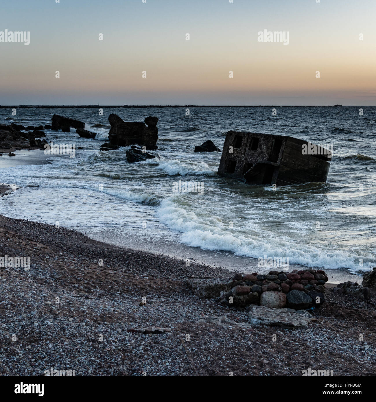 old war fort ruins on the beach with high waves in sunset. Liepaja ...