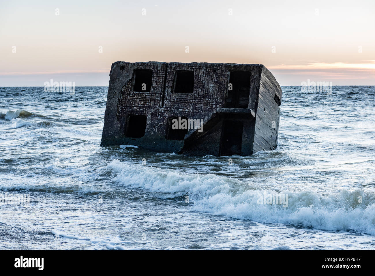 old war fort ruins on the beach with high waves in sunset. Liepaja ...