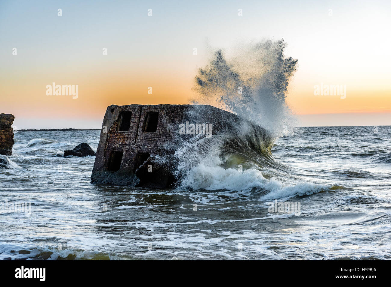 old war fort ruins on the beach with high waves in sunset. Liepaja ...