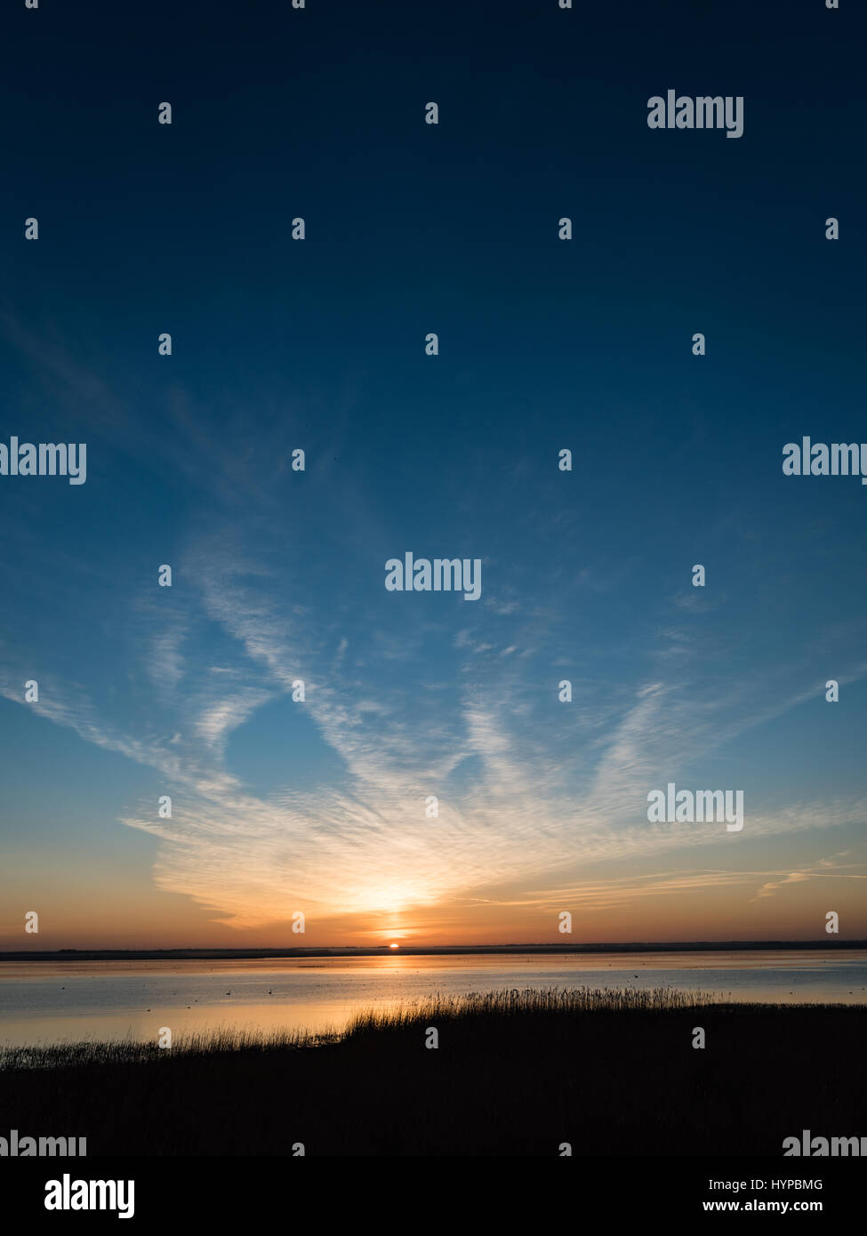 beautiful sunrise over country lake with orange clouds and reflections ...