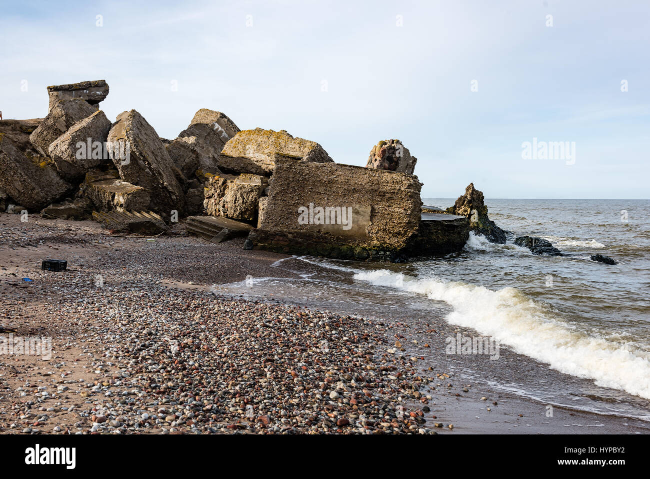 old war fort ruins on the beach with high waves in sunset. Liepaja ...