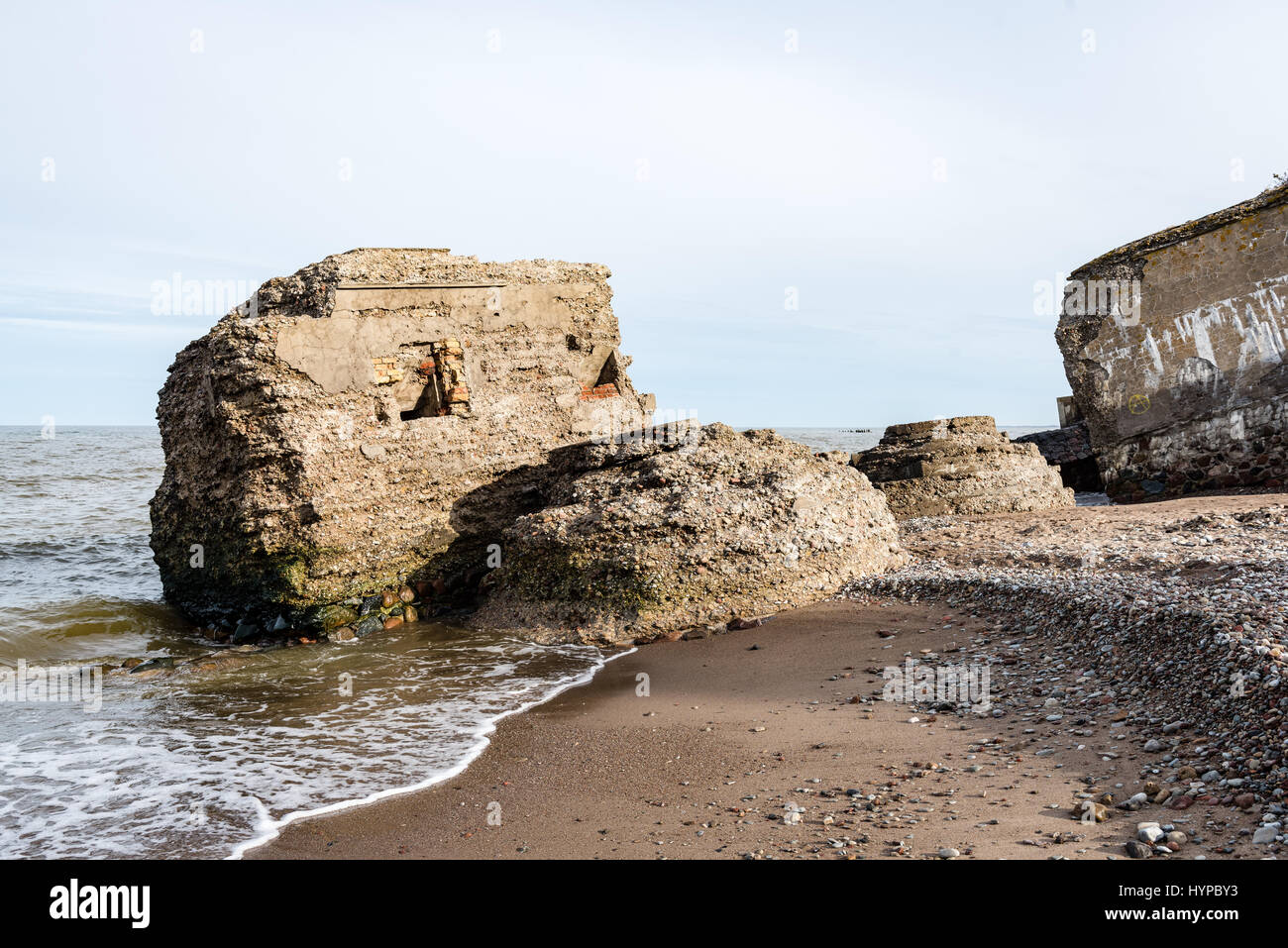 old war fort ruins on the beach with high waves in sunset. Liepaja ...