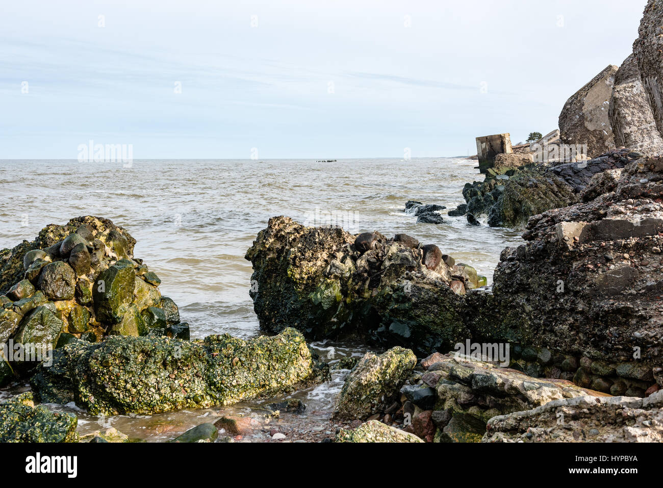 old war fort ruins on the beach with high waves in sunset. Liepaja ...