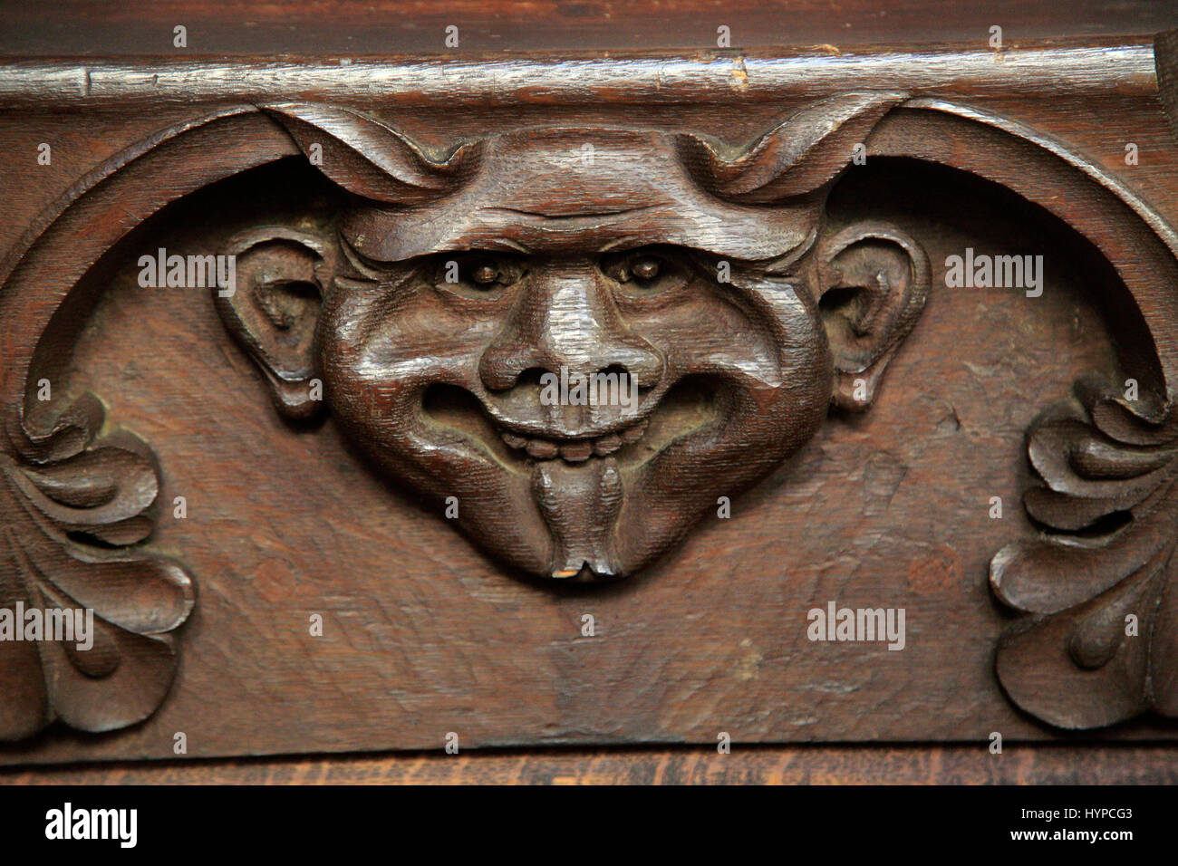 Wooden carved devil face in bench seat, Ufford church, Suffolk, England ...