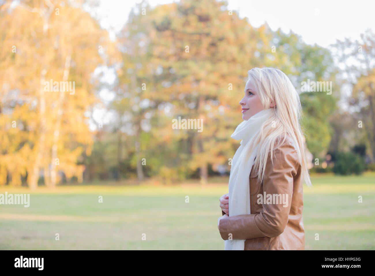 Side view of a pretty blonde woman in Park in Autumn Stock Photo - Alamy