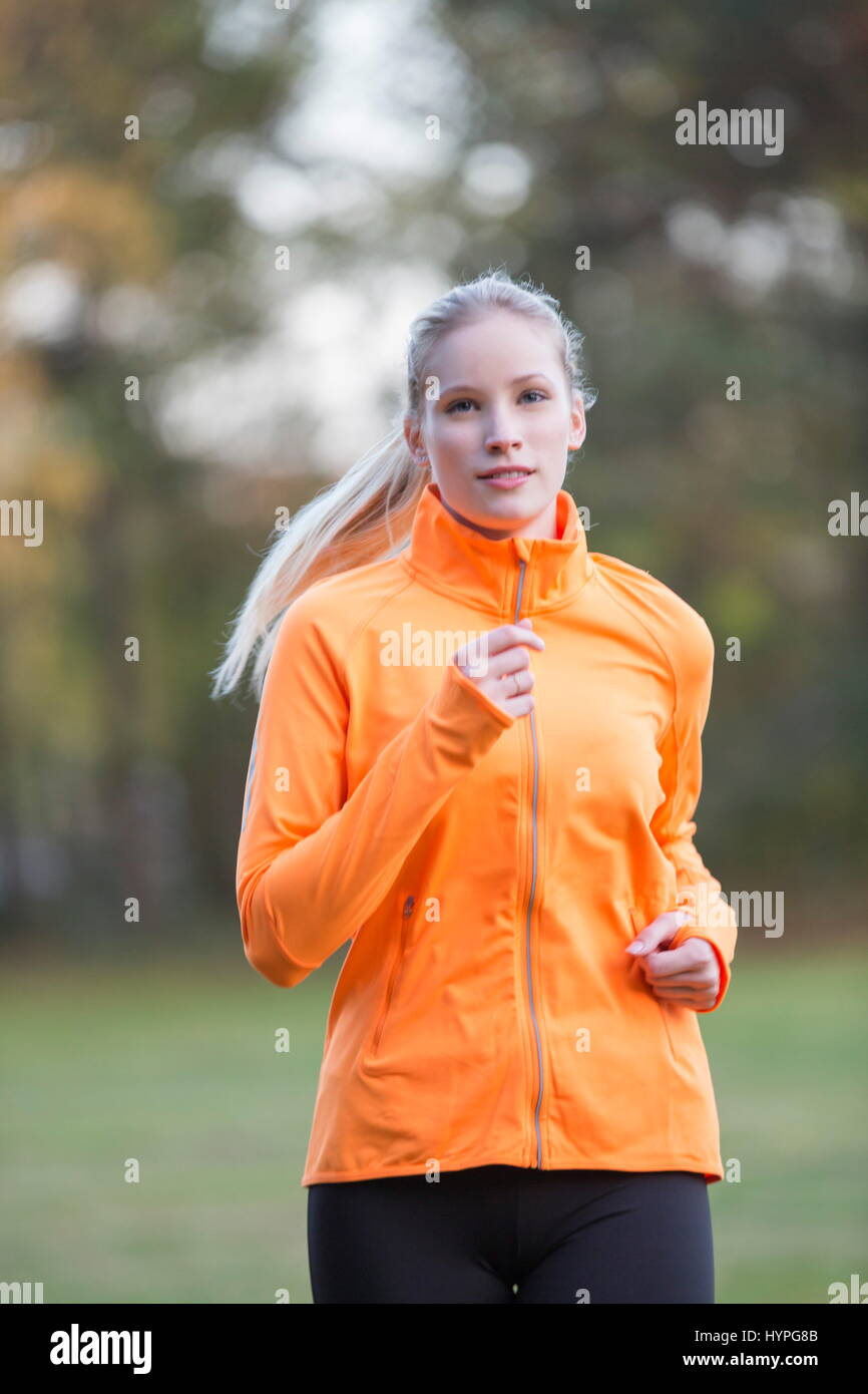Pretty blonde woman doing jogging in park Stock Photo - Alamy