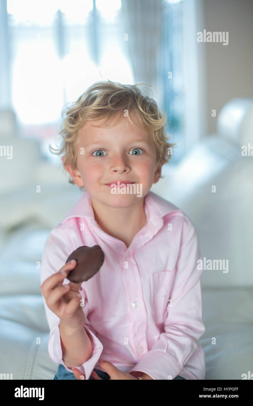 Cute little boy with cookie looking at camera Stock Photo - Alamy
