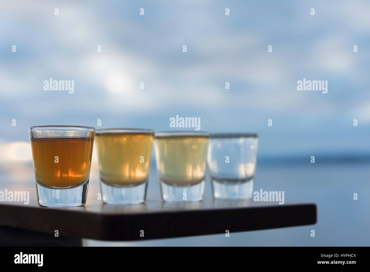 Four shots of a variety of tequila on seaside table Stock Photo - Alamy