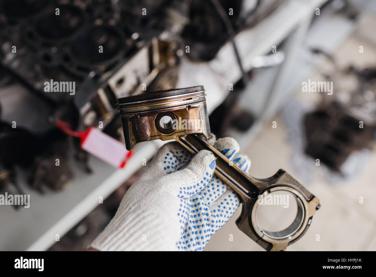Car mechanic in garage with old car engine piston Stock Photo - Alamy