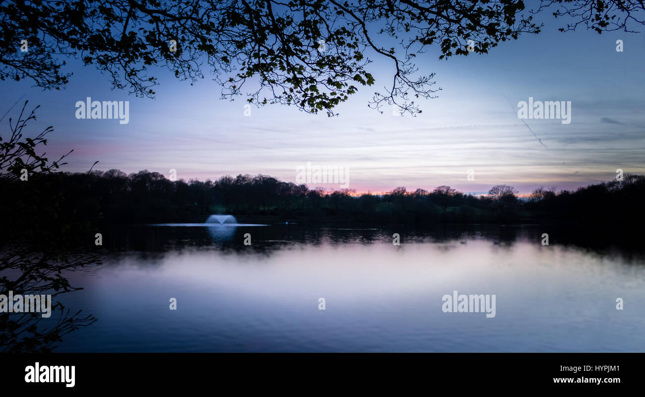 a beautiful sunset across a boating/fishing lake with a fountain Stock ...