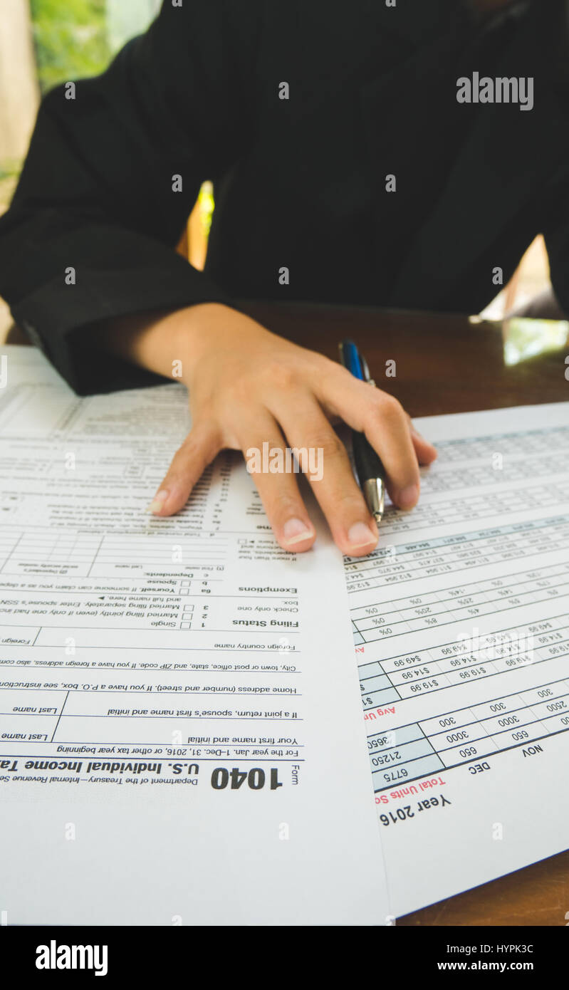 Business woman hand hold on the tax forms paper in business concept ...