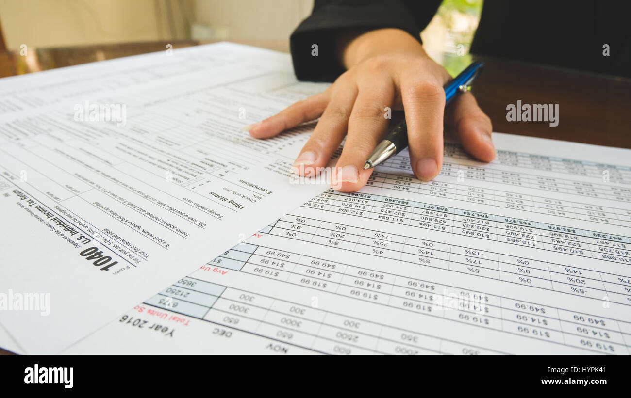 Business woman hand hold on the tax forms paper in business concept ...