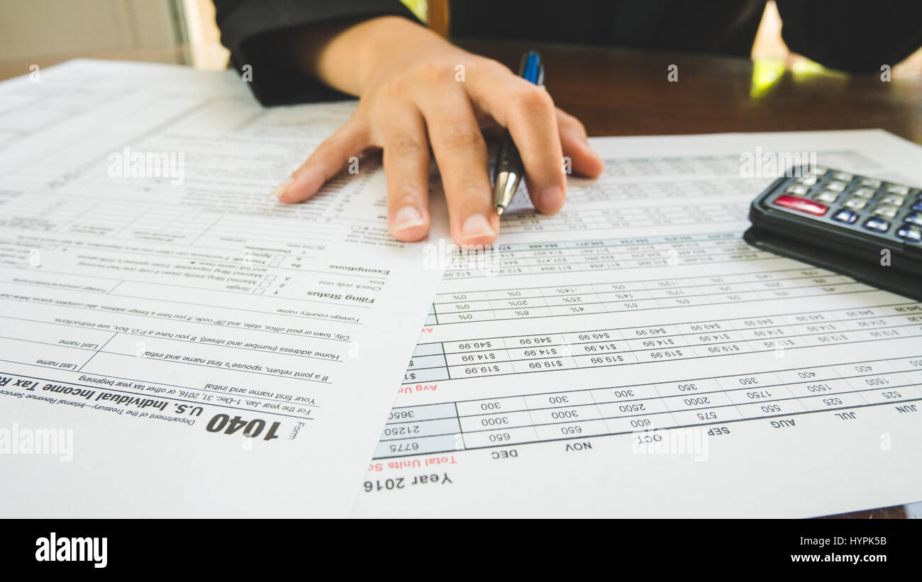 Business woman hand hold on the tax forms paper in business concept ...