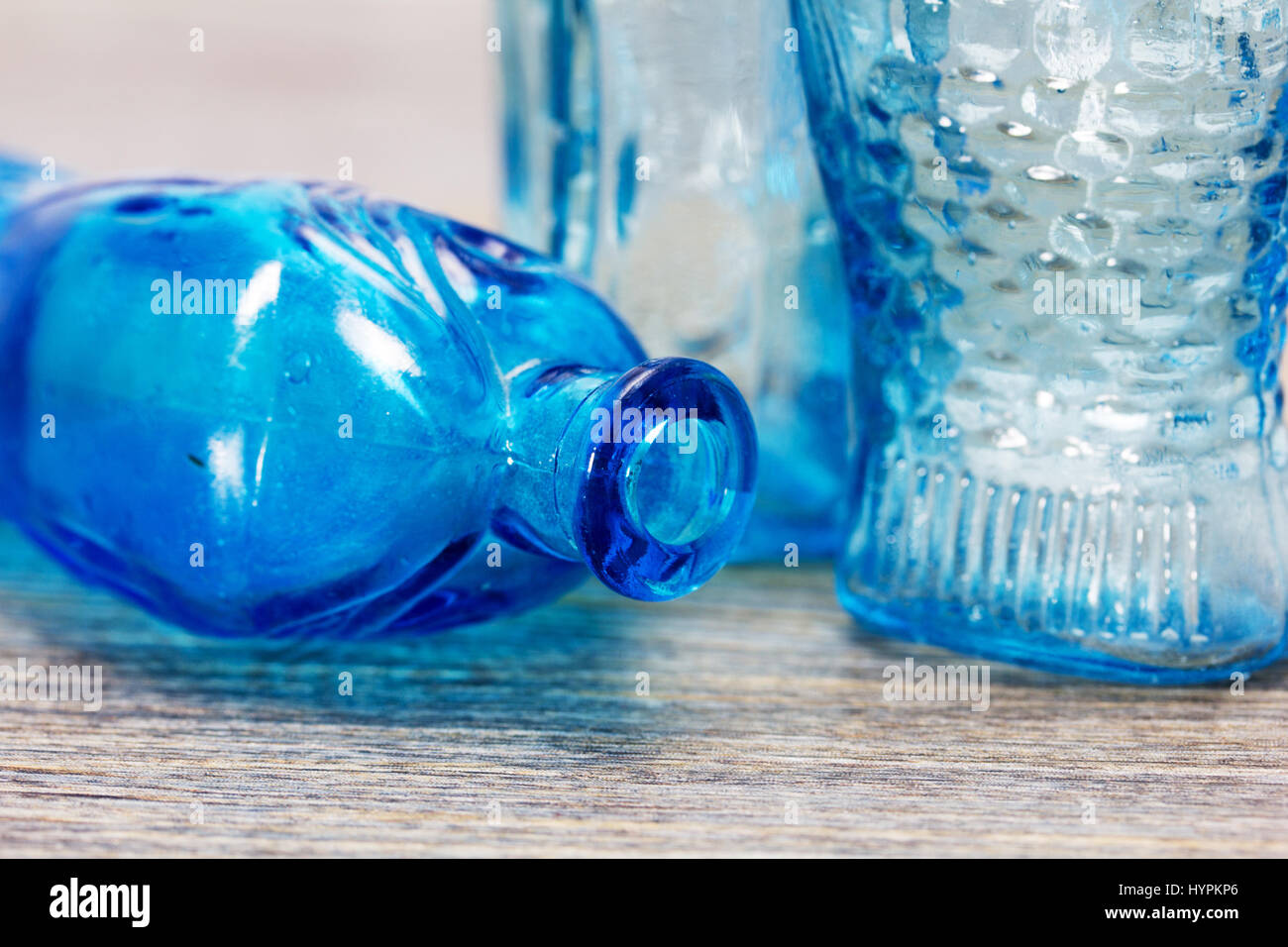 Selection of coloured glass bottles on a rustic background Stock Photo ...