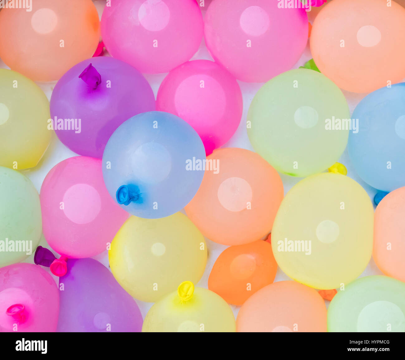 background of colorful water balloons ready for action on a hot summer ...