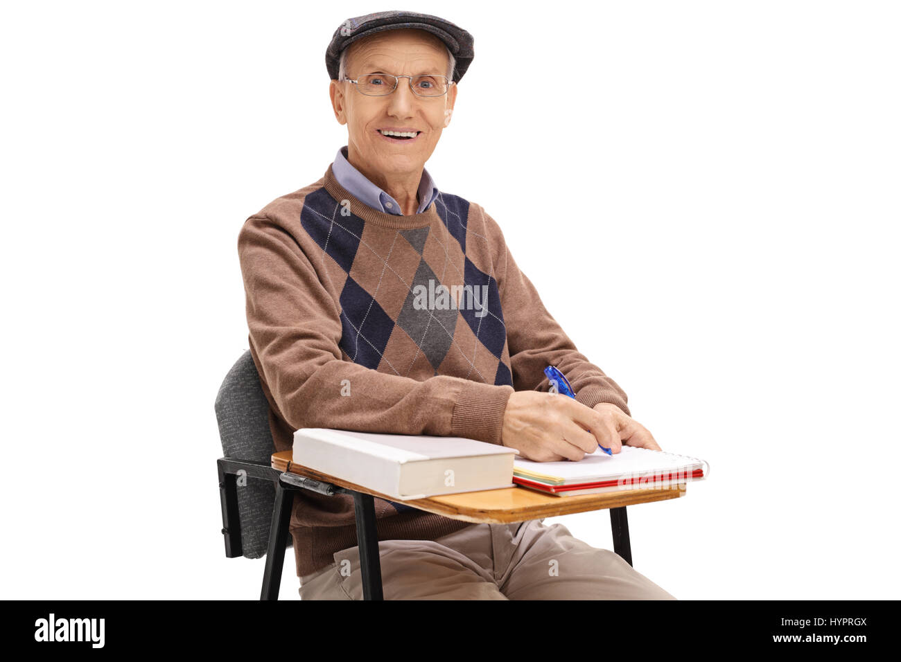Elderly student in a school chair taking notes and looking at the ...