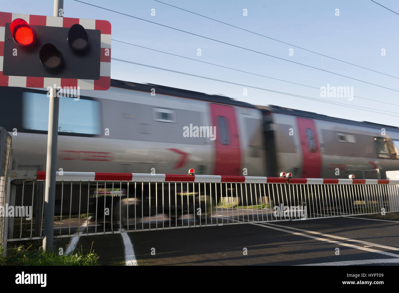 Train passing through a level crossing Stock Photo - Alamy
