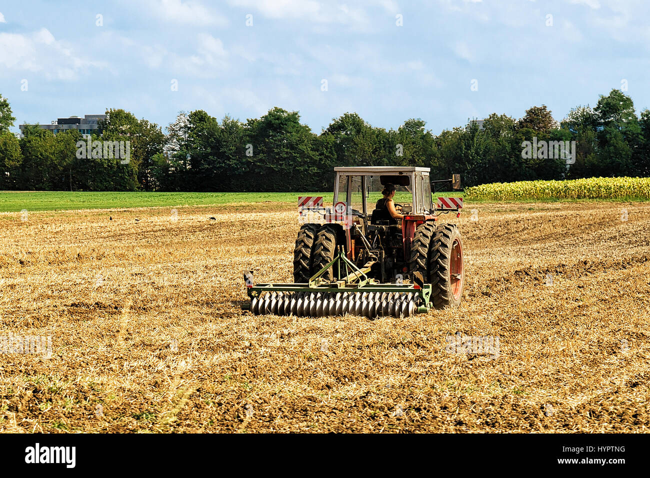 Tractor with plough doing agricultural seasonal work at the field Stock ...