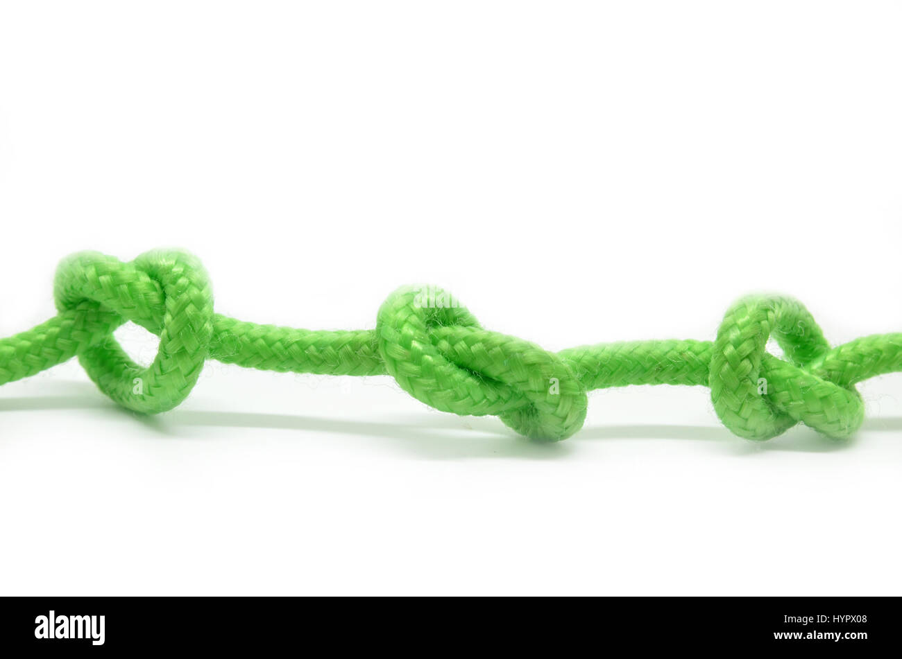Three tied knots on green rope, isolated Stock Photo - Alamy