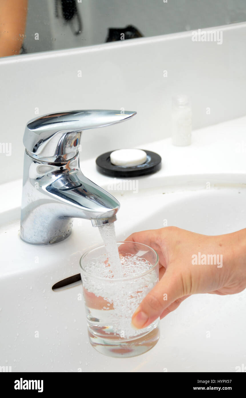 Filling a glass with water under the tap Stock Photo - Alamy