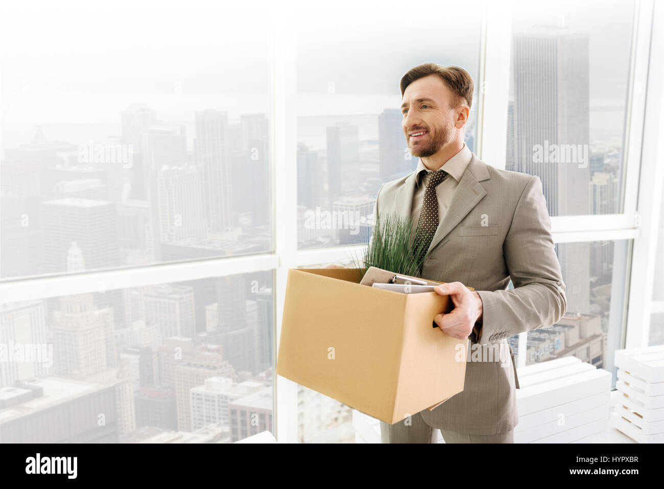 Cheerful employee getting ready to work in a new office Stock Photo - Alamy