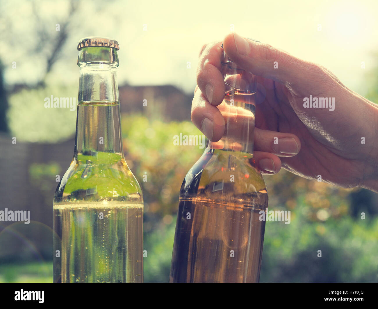 Young man with two bottles of apple juice in the garden Stock Photo - Alamy