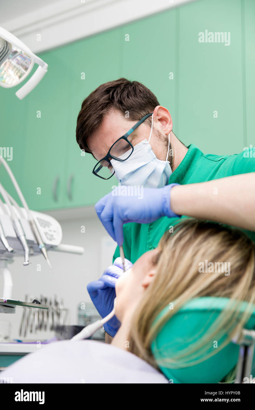 Close-up picture of young lady having her teeth examined by a dentist ...