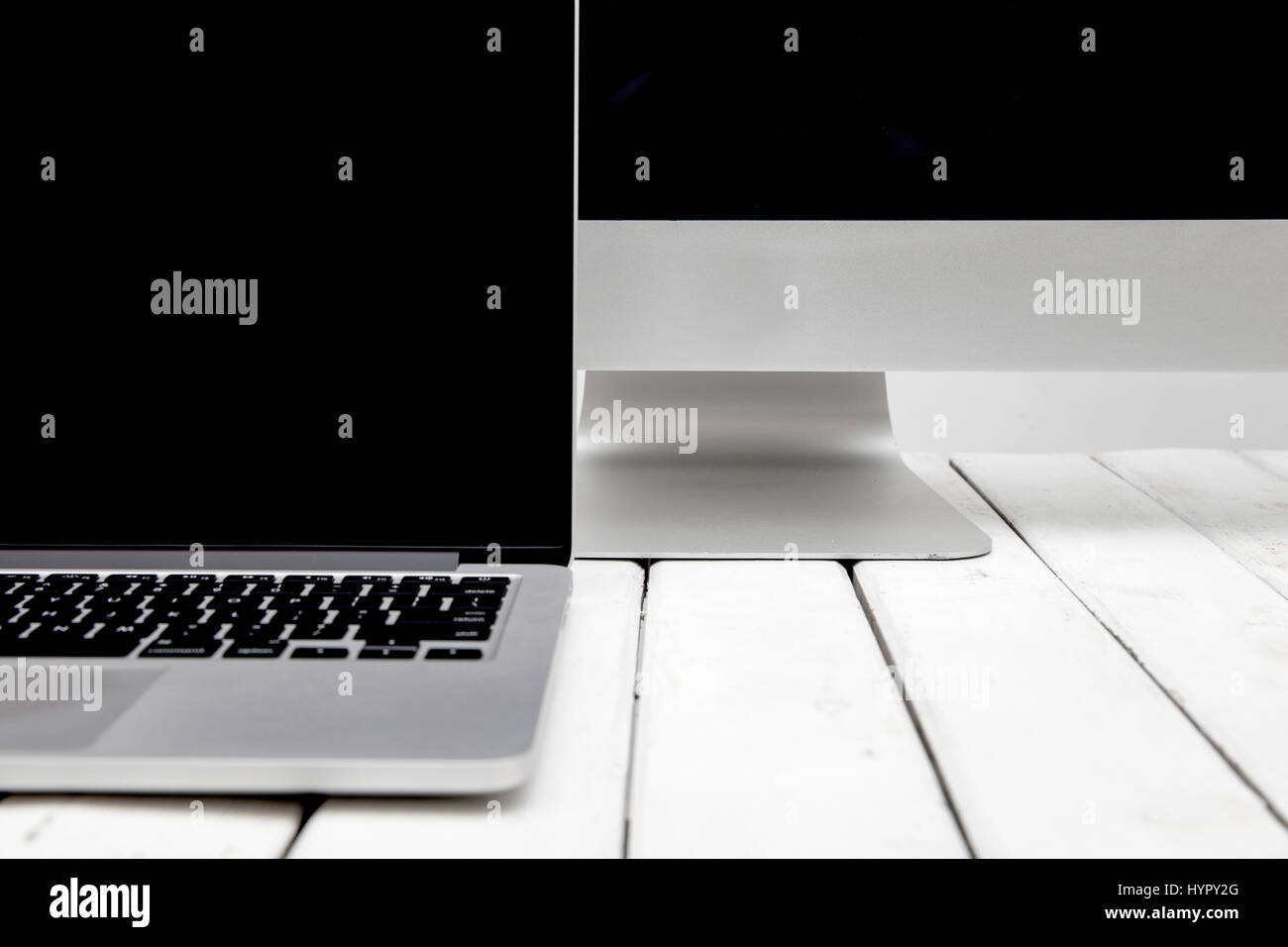 Laptop with black screen on white wooden table by white background ...