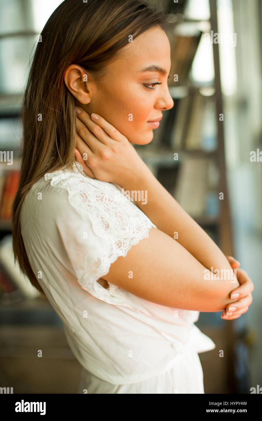 Young woman standing by window Stock Photo - Alamy