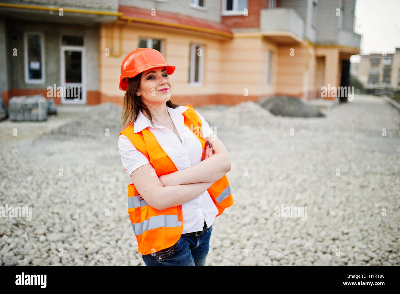Engineer builder woman in uniform waistcoat and orange protective ...