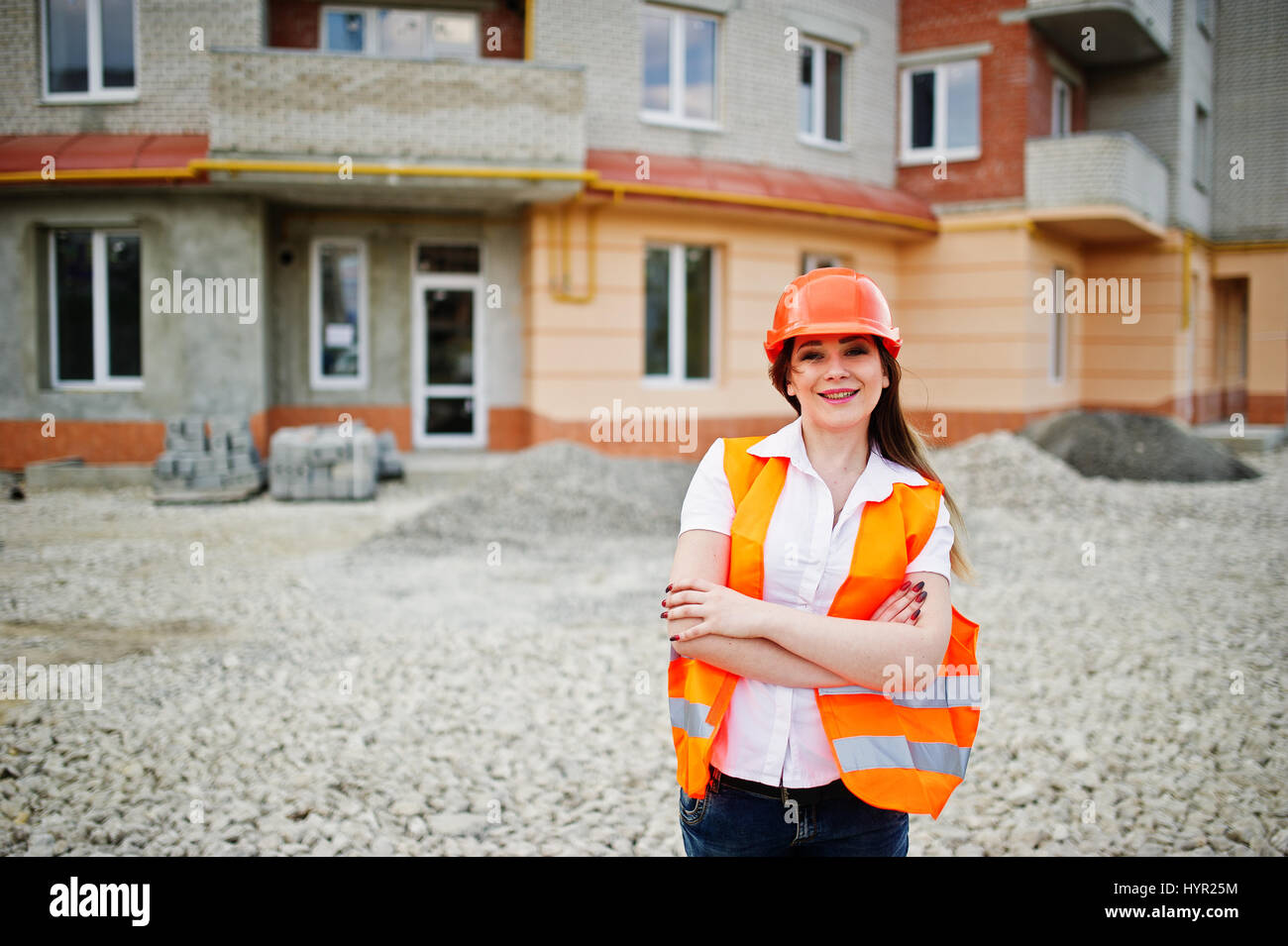 Engineer builder woman in uniform waistcoat and orange protective ...