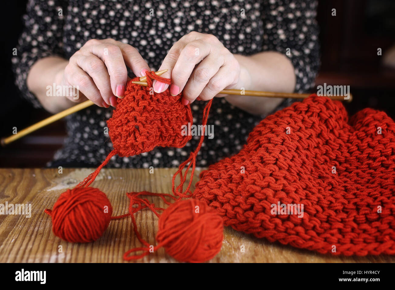 elderly woman is engaged in knitting warm sweaters for her grand Stock ...