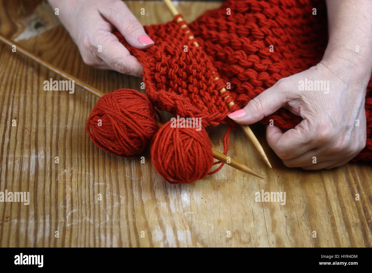 elderly woman is engaged in knitting warm sweaters for her grand Stock ...