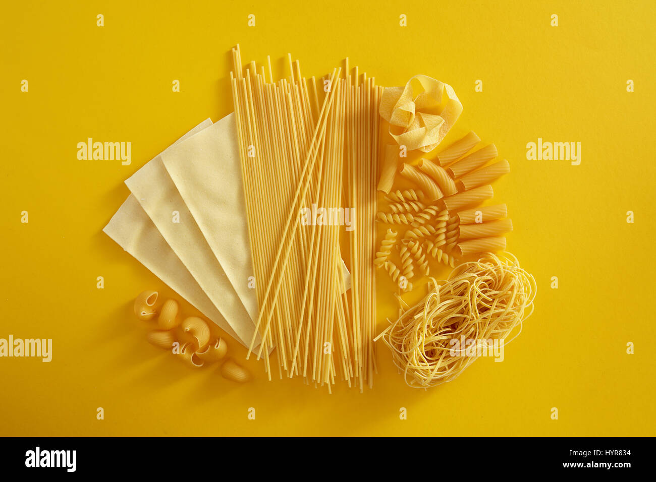 Assorted types of pasta on yellow background. Various forms of pasta ...