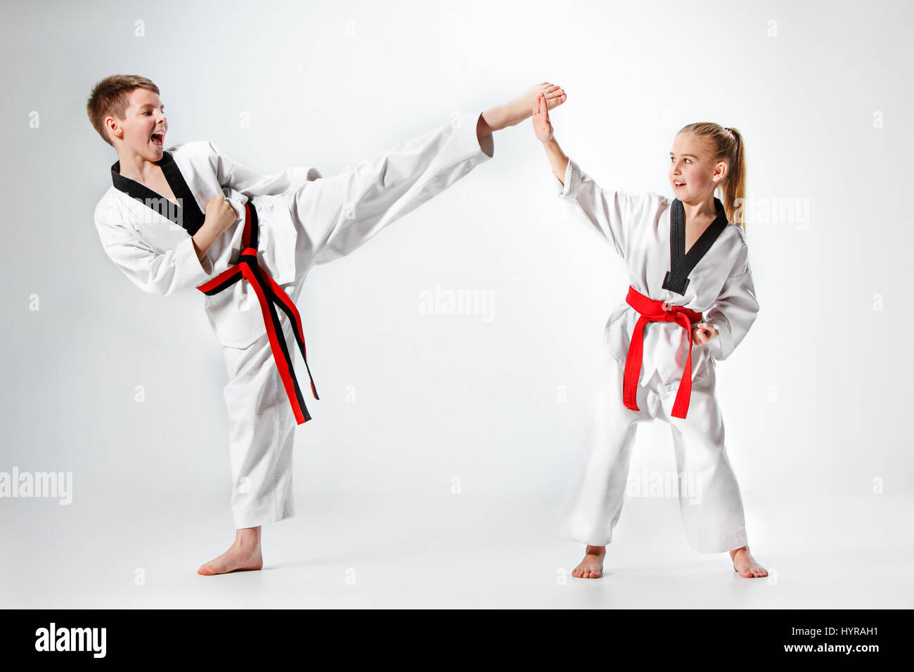 The studio shot of group of kids training karate martial arts on gray ...