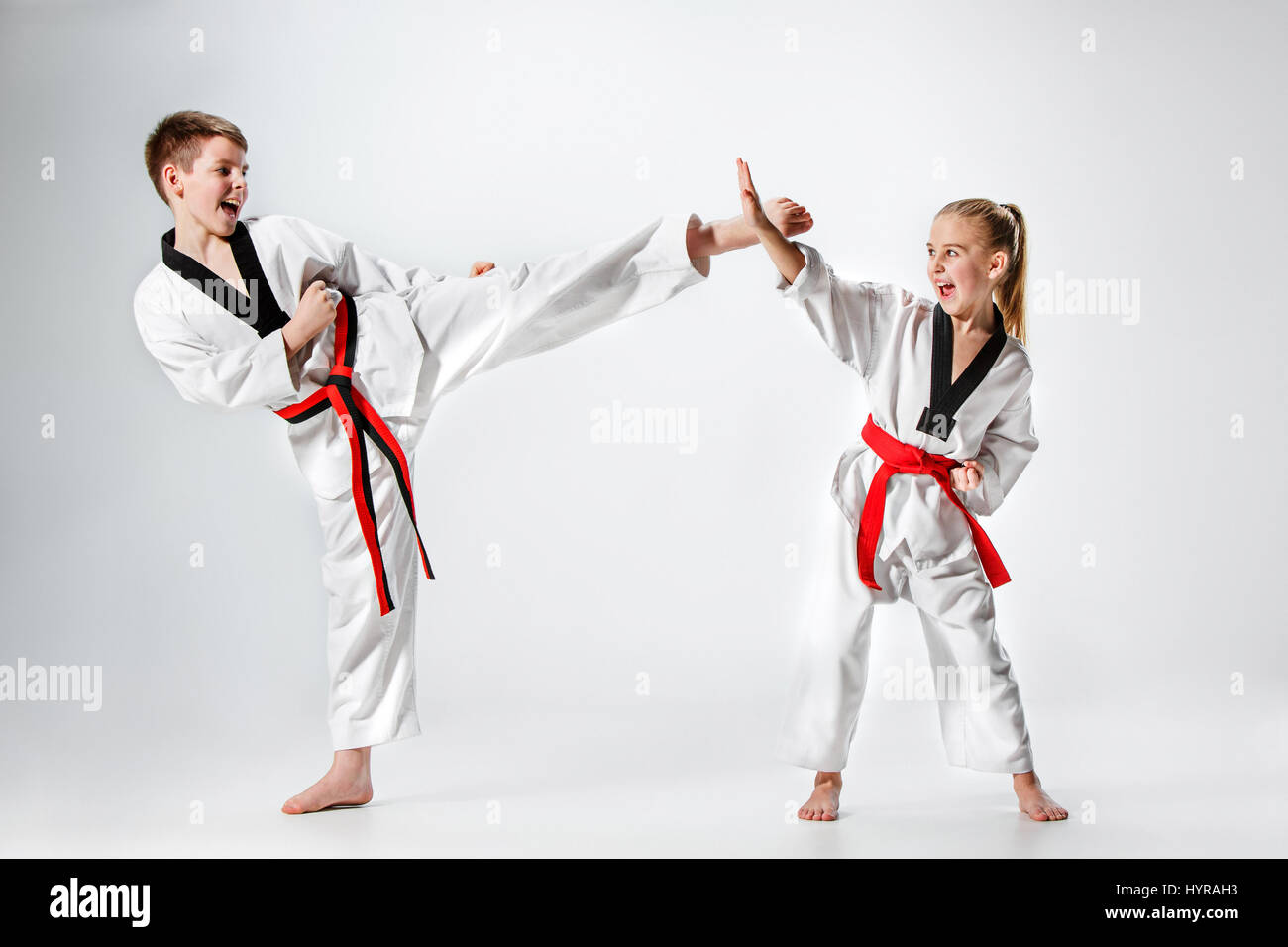 The studio shot of group of kids training karate martial arts on gray ...