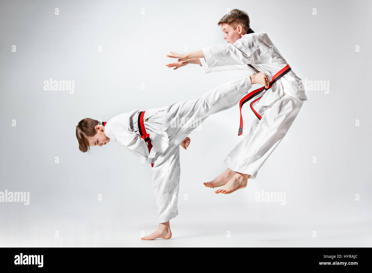 The studio shot of group of kids training karate martial arts on gray ...