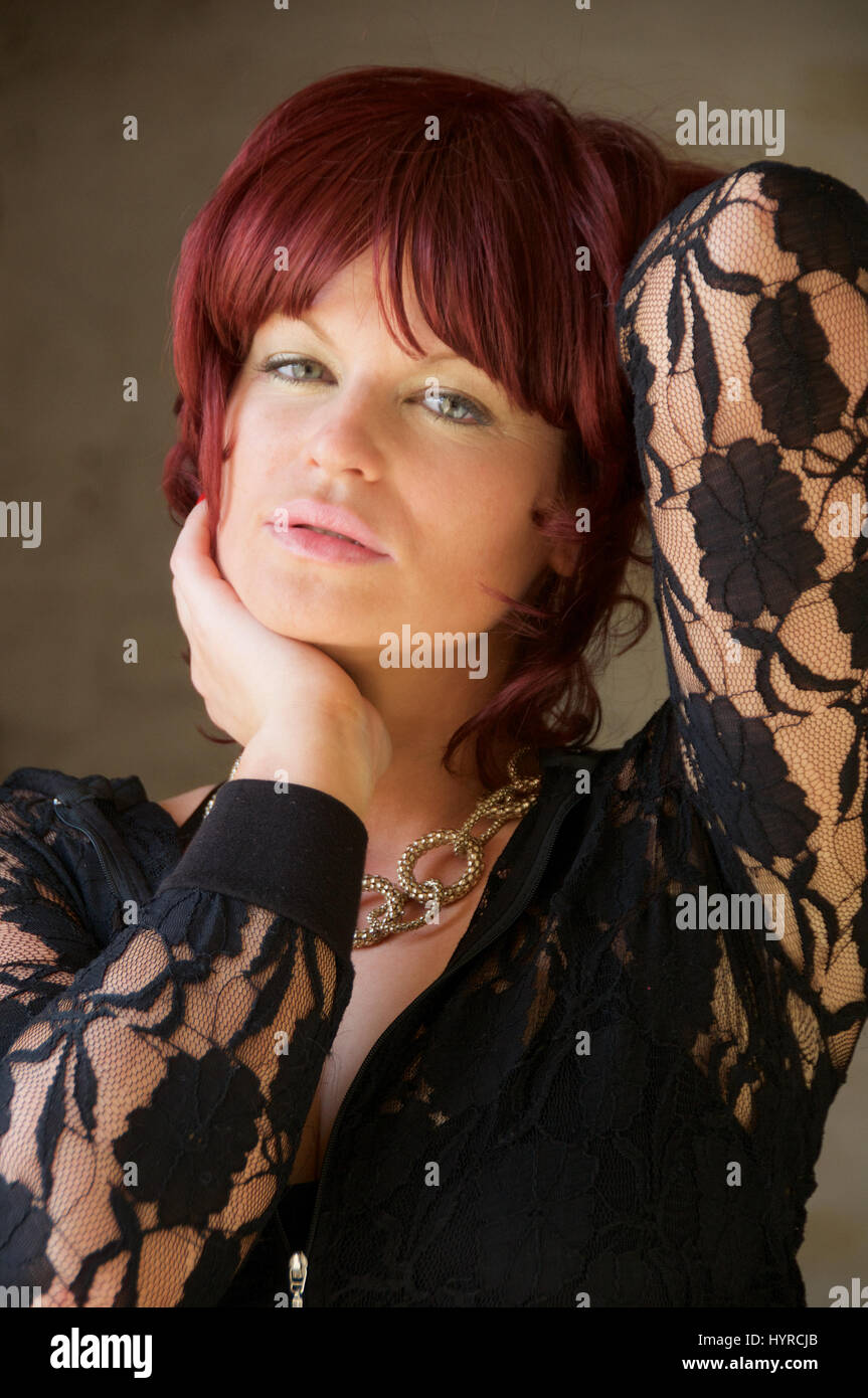 Beautiful red-haired young woman head and shoulders, wearing black ...