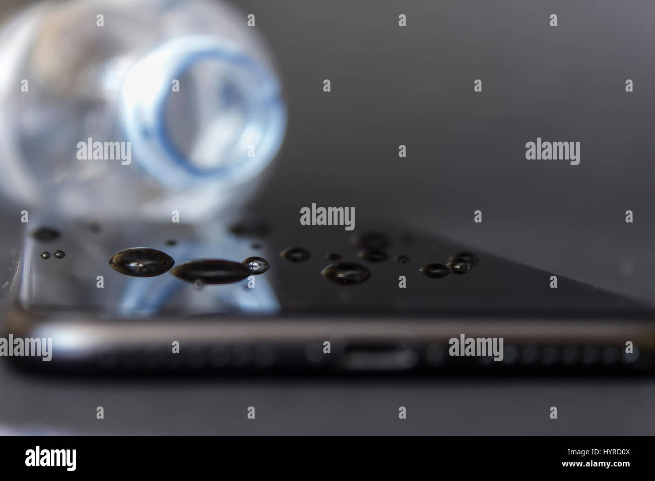 Water spilled from a bottle onto a smartphone Stock Photo - Alamy