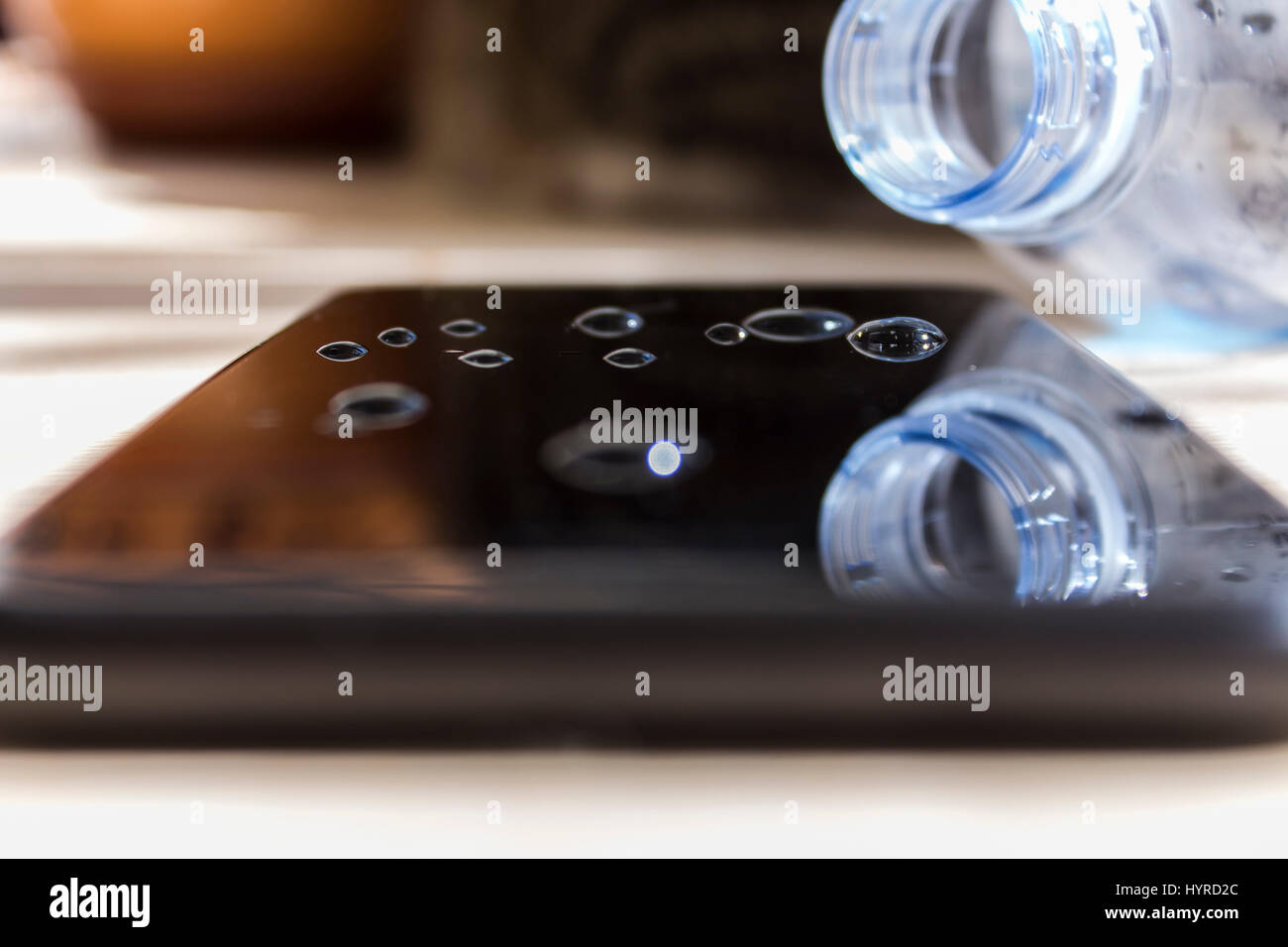 Water spilled from a bottle onto a smartphone Stock Photo - Alamy