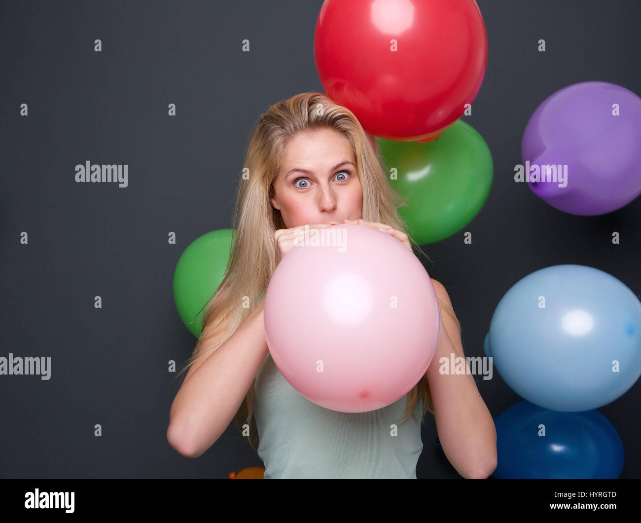 Portrait of a blond woman inflating balloons for a party Stock Photo ...