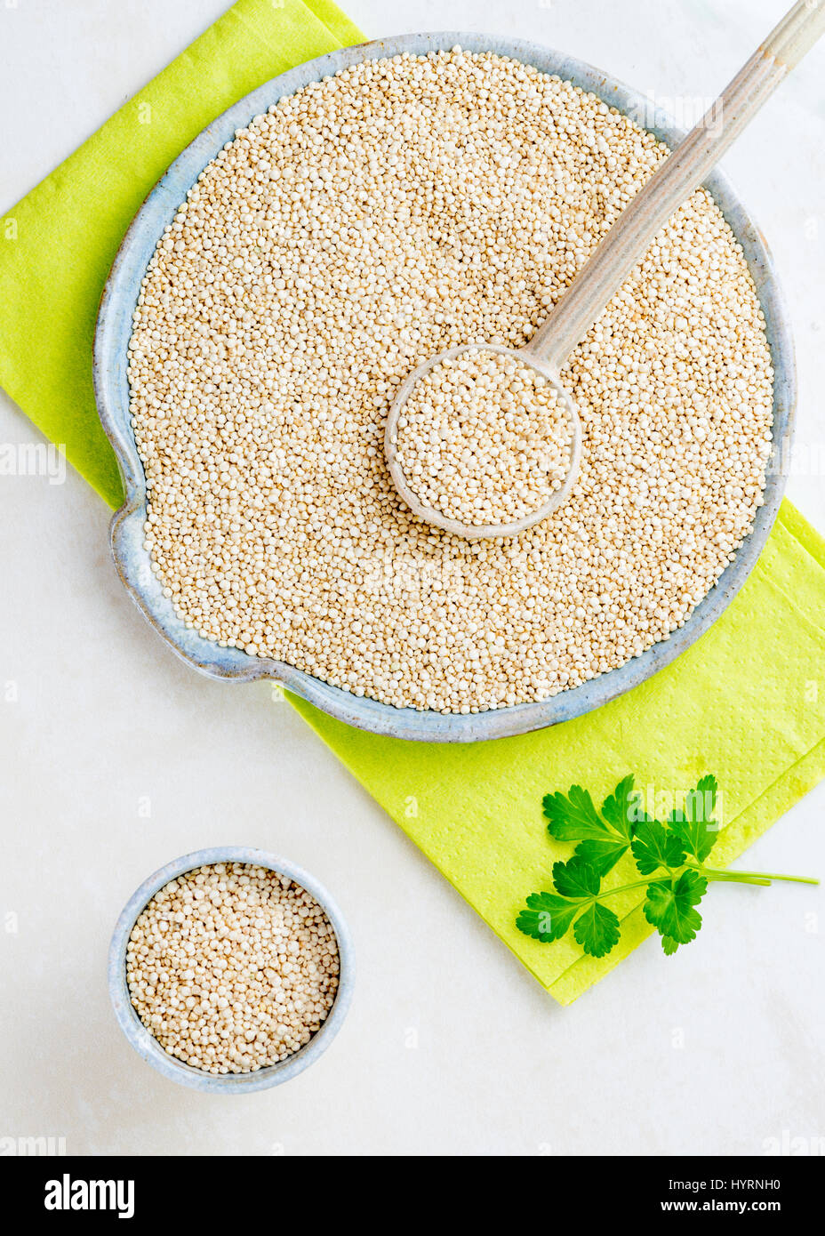 Vertical image of bio quinoa in a large ceramic dish with a spoon and a ...
