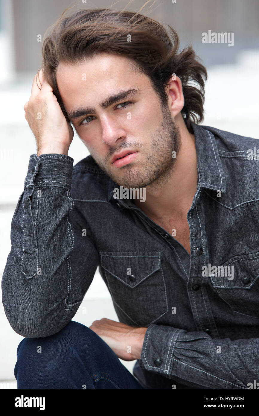 Close up portrait of a male fashion model sitting outside Stock Photo ...